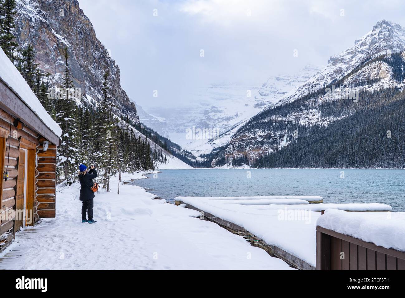 Unidentifiable woman taking a photo at Lake Louise in winter Stock ...