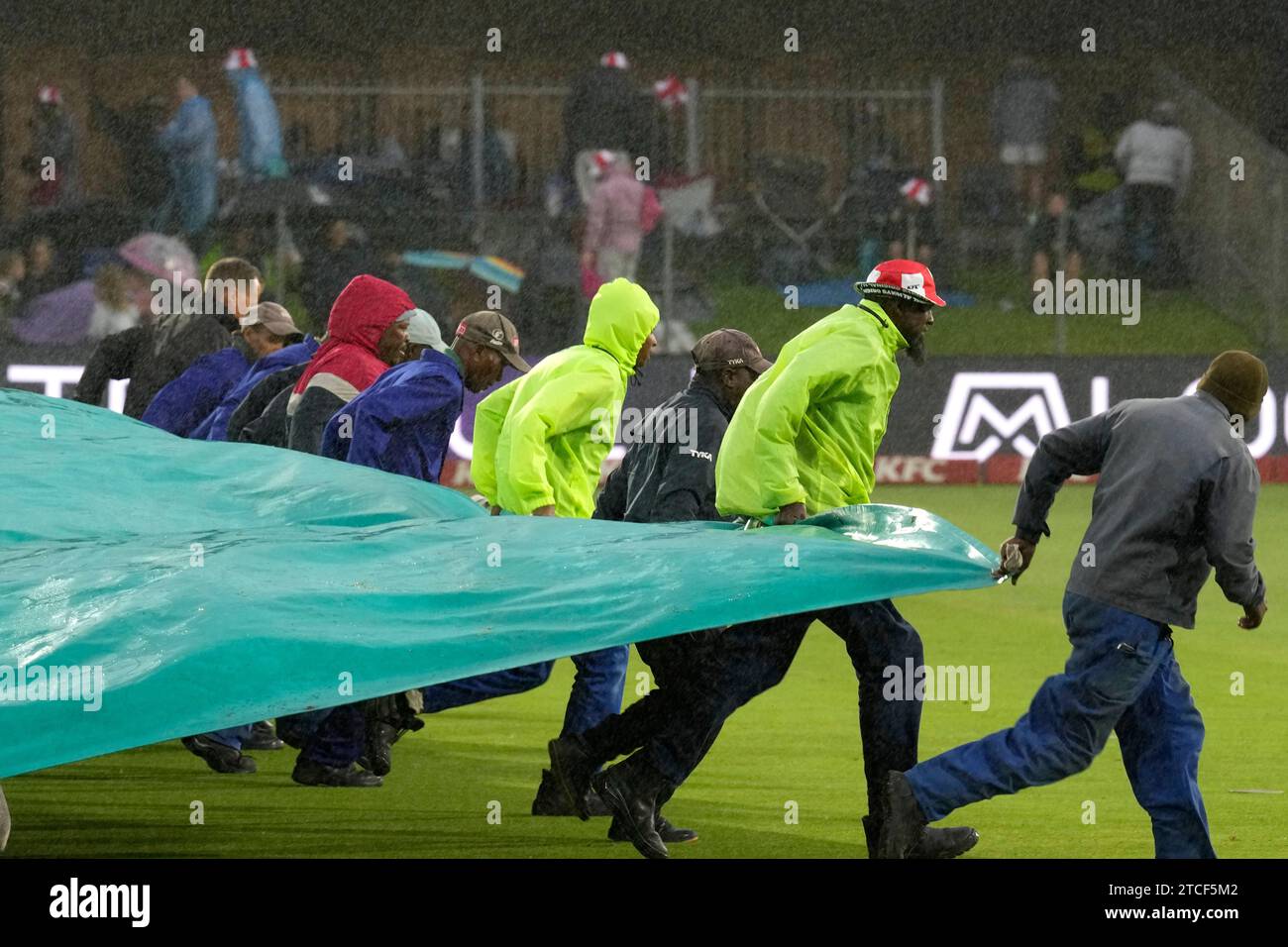 Ground workers pull rain cover as plays is delayed during the second ...