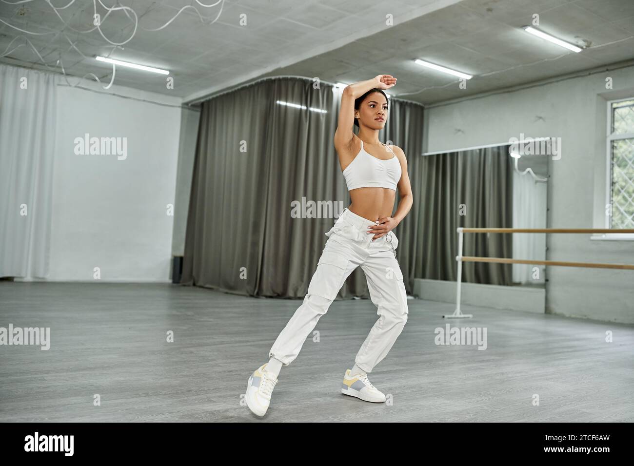 rhythmic african american dancer in white sportswear rehearsing and ...