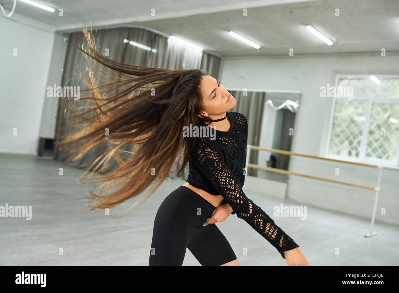 dynamic long-haired african american dancer in black attire rehearsing ...