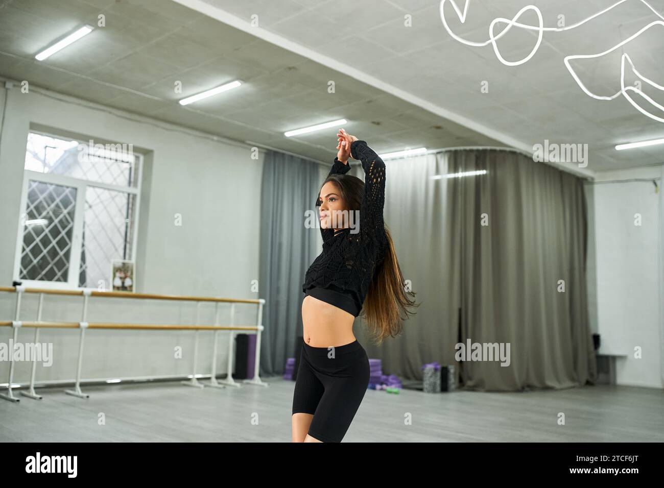 expressive african american dancer in black attire rehearsing in dance ...