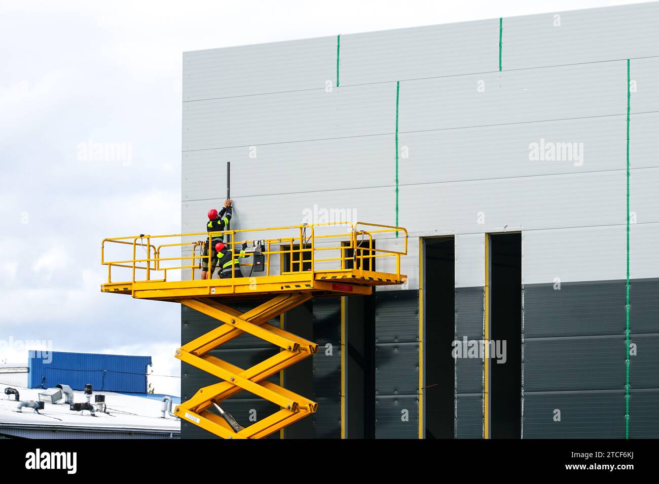 Large elevated aerial scissor lift working platform with workers ...