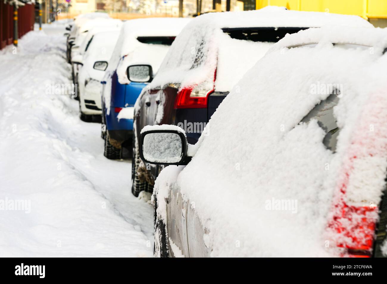 Row of parked snowy cars on snowy street, cars covered with fresh snow ...