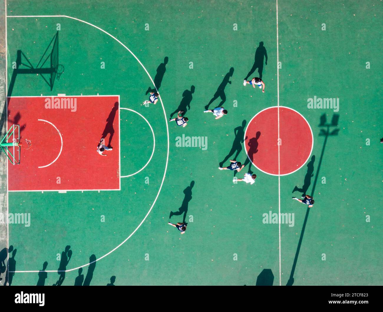 An aerial view of a group of young people playing basketball on a ...