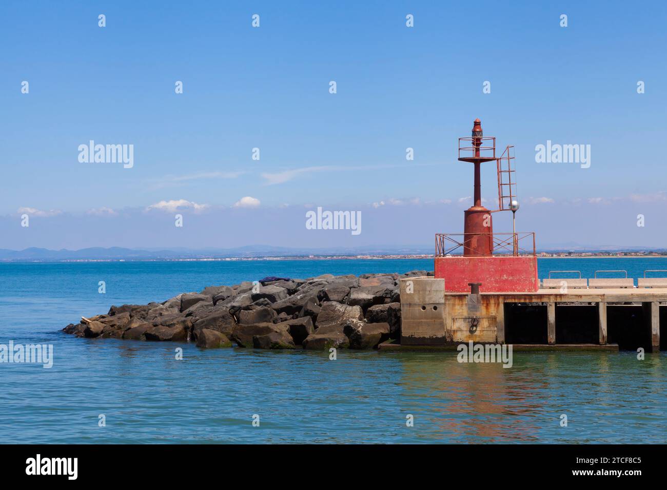 Fiumicino port’s rocky dock end, mini lighthouse overlooks sea ...