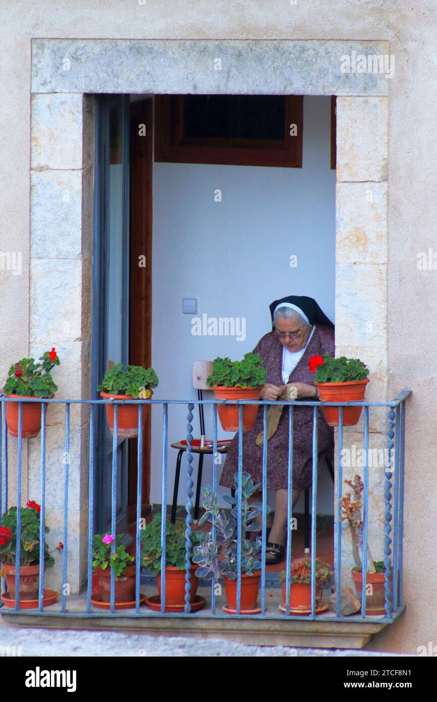Nun on a balcony, keeping busy, near Girona Cathedral Stock Photo - Alamy