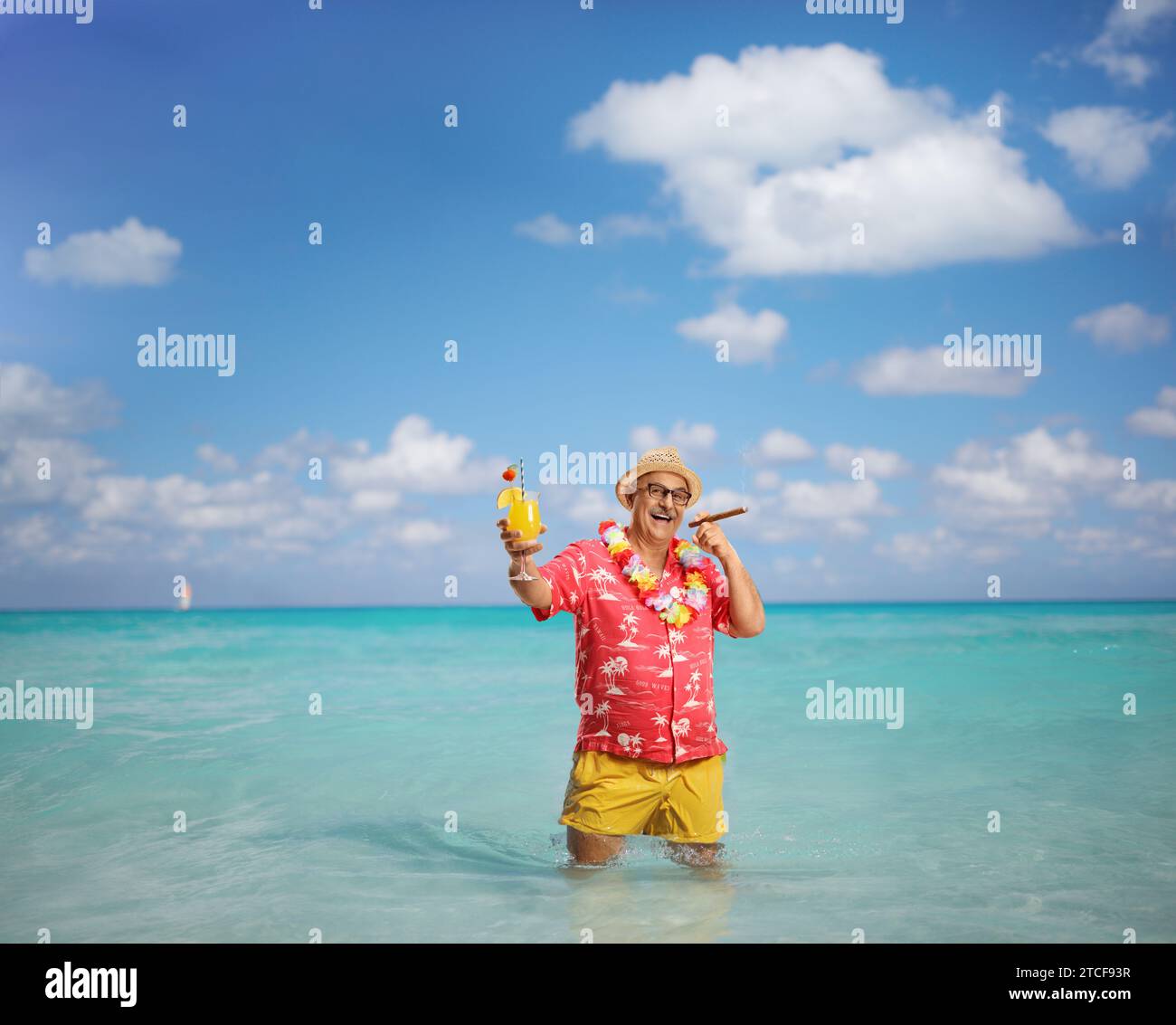 Man standing in the sea, smoking a cigar and holding a glass of ...