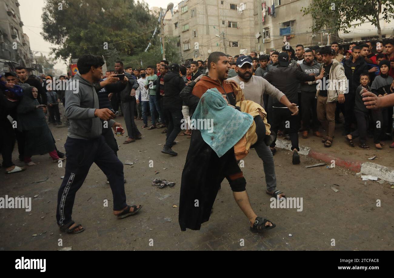 Rafah, Gaza. 12th Dec, 2023. Palestinians carry the injured following ...