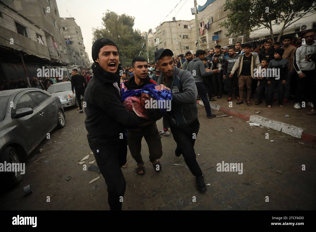 Rafah, Gaza. 12th Dec, 2023. Palestinians carry the injured following ...