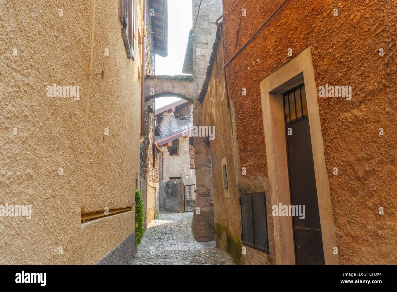 Narrow alley between stucco walled building in Menaggio, Italy ...