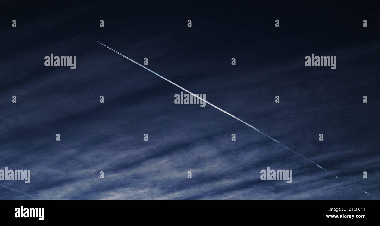 Jet plane with ultra-bright contrail cuts a perfect diagonal across an ...