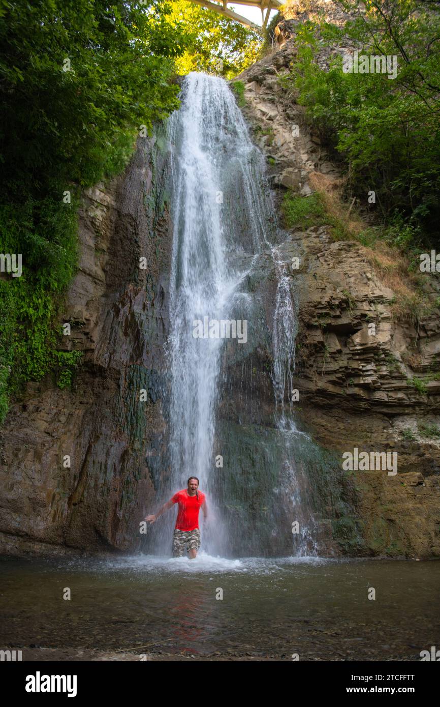 Mystic Encounter: Man in Red Transfixed by the Waterfall Stock Photo ...