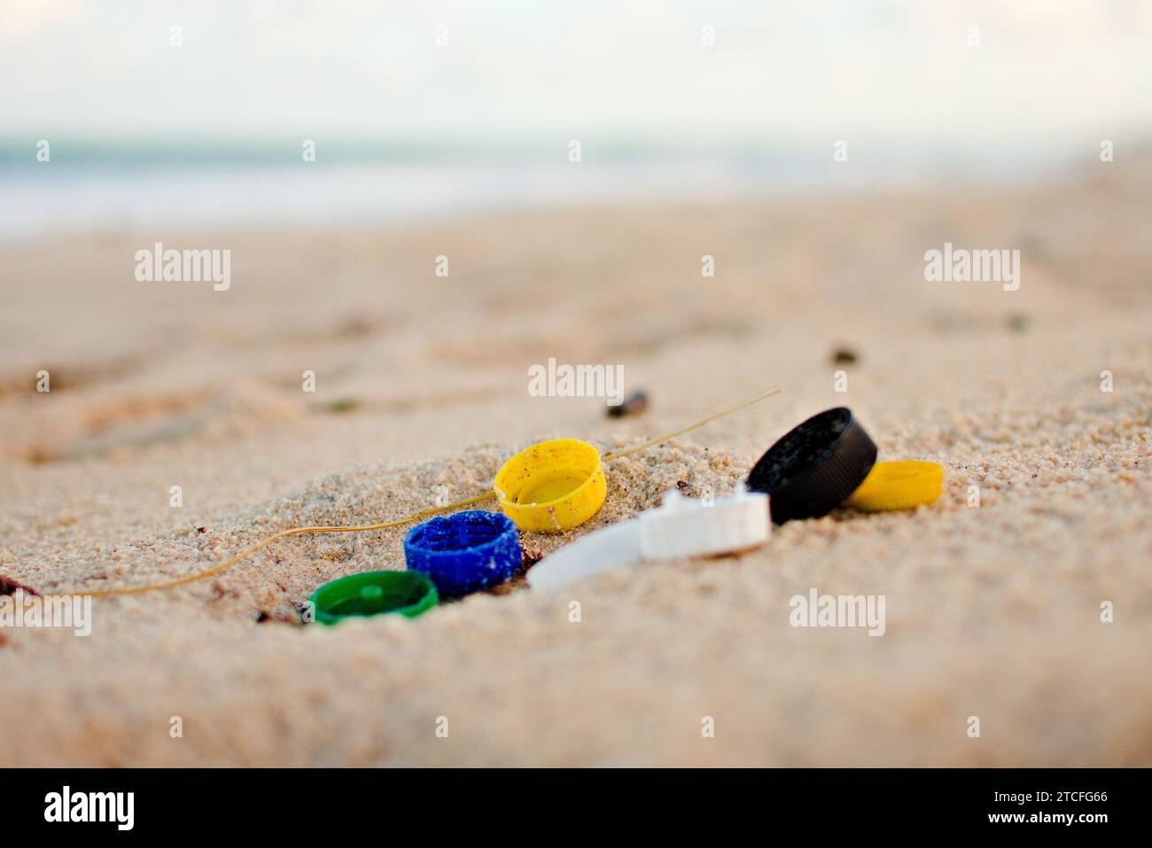 Assorted plastic bottle caps discarded on the sand at a beach in Brazil ...