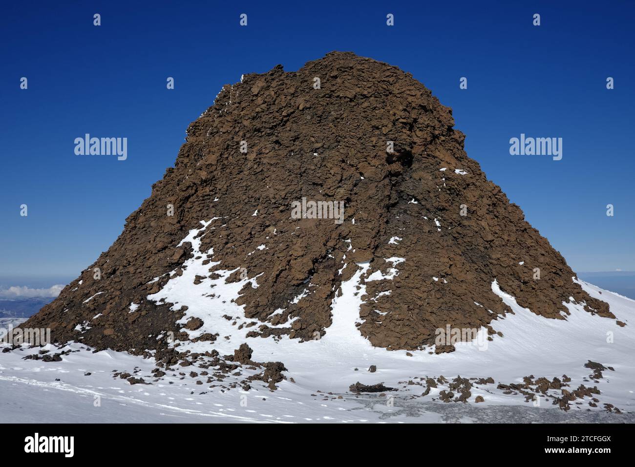 snowy lava field with a hornito on mountainside of Mount Etna North ...