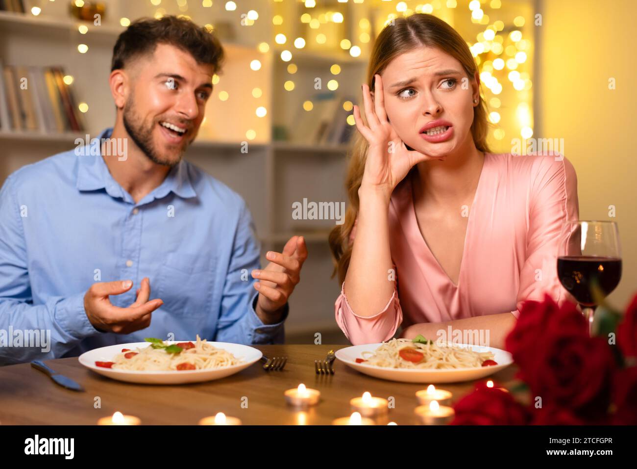 Woman annoyed at man's talk during dinner Stock Photo - Alamy