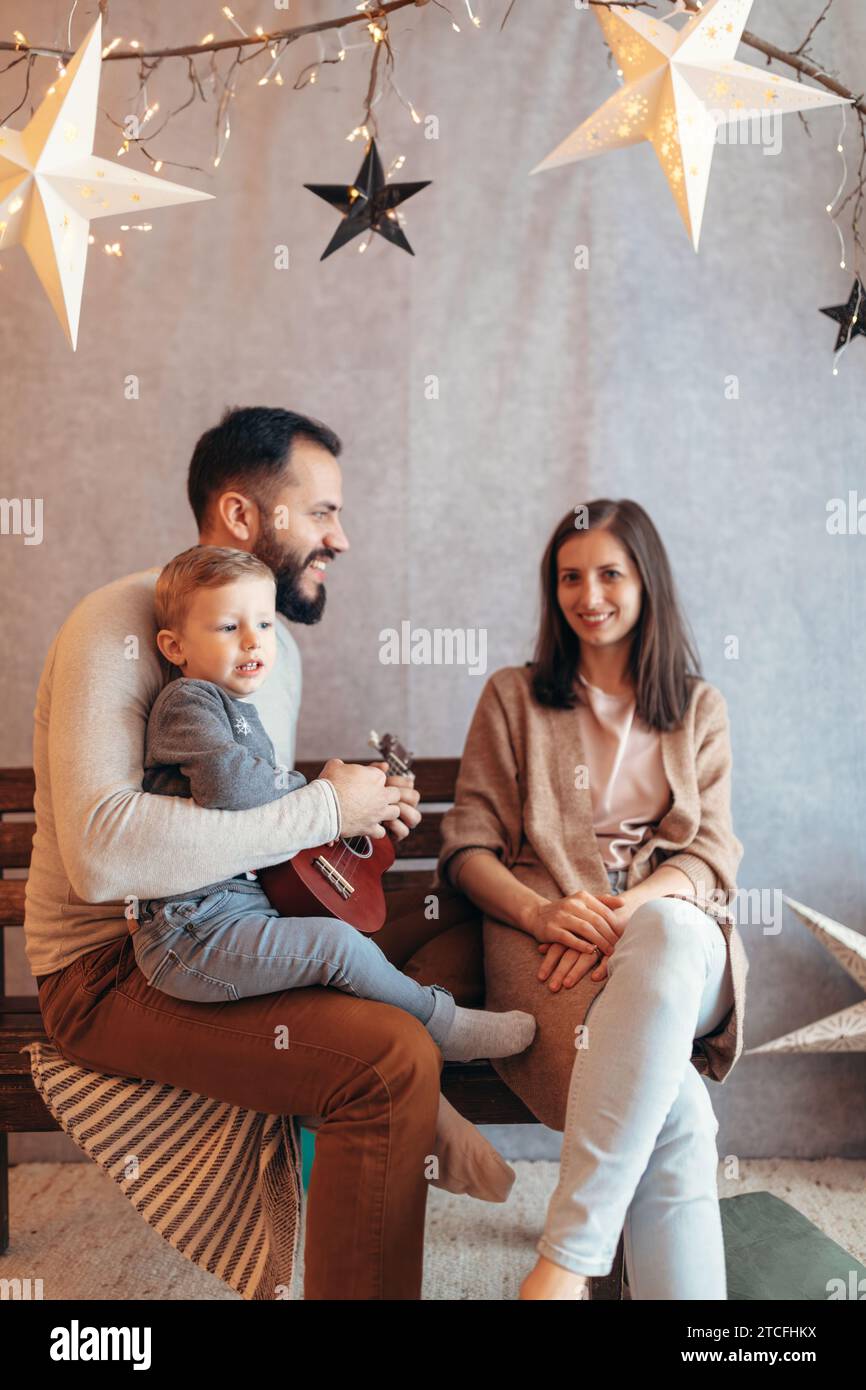 The parents, beaming with happiness, embrace their little boy as he ...