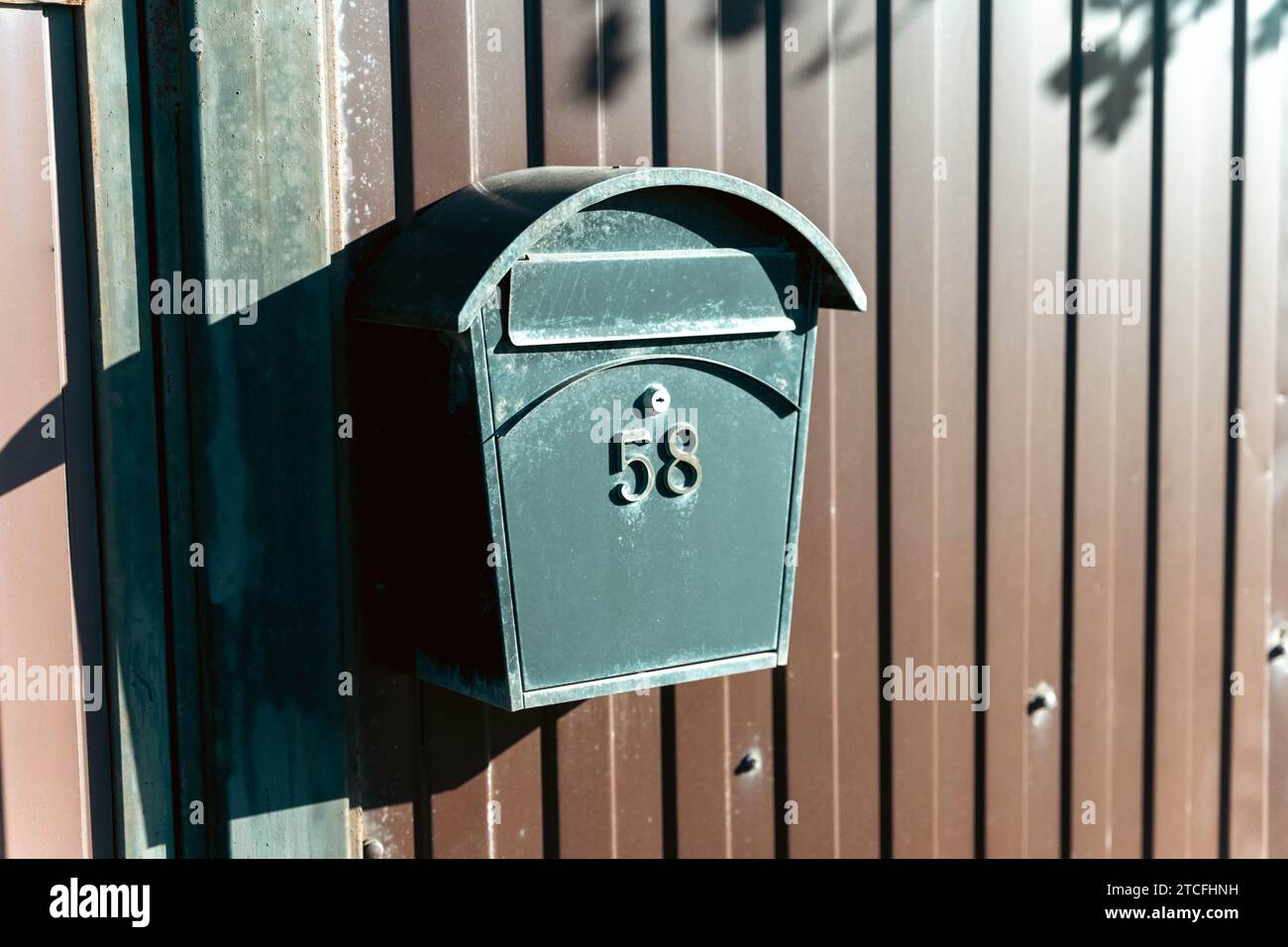 A classic red mailbox stands at the gate of a charming private house in ...