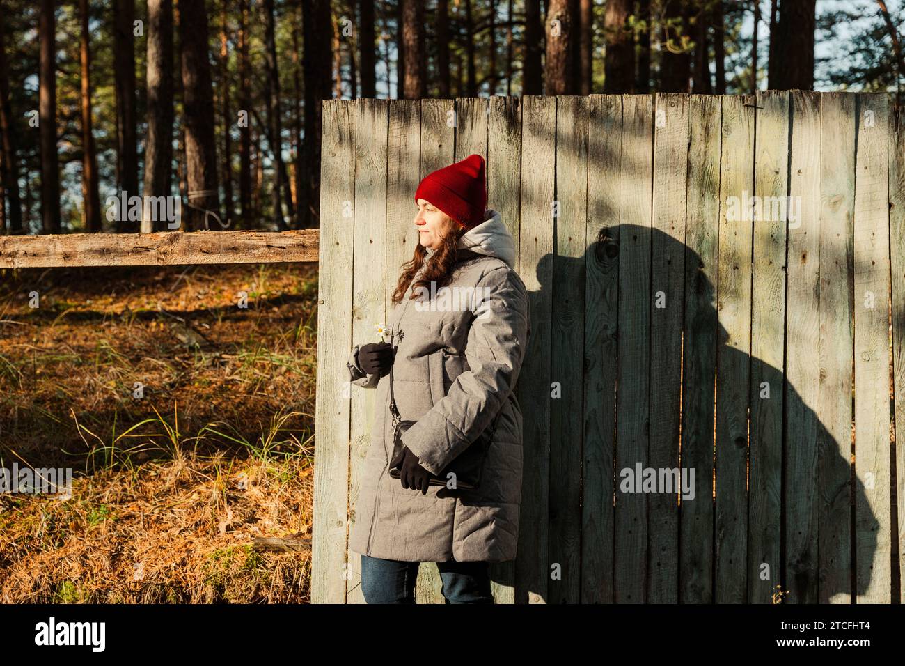 A middle-aged woman exudes autumn elegance as she strikes a pose by an ...
