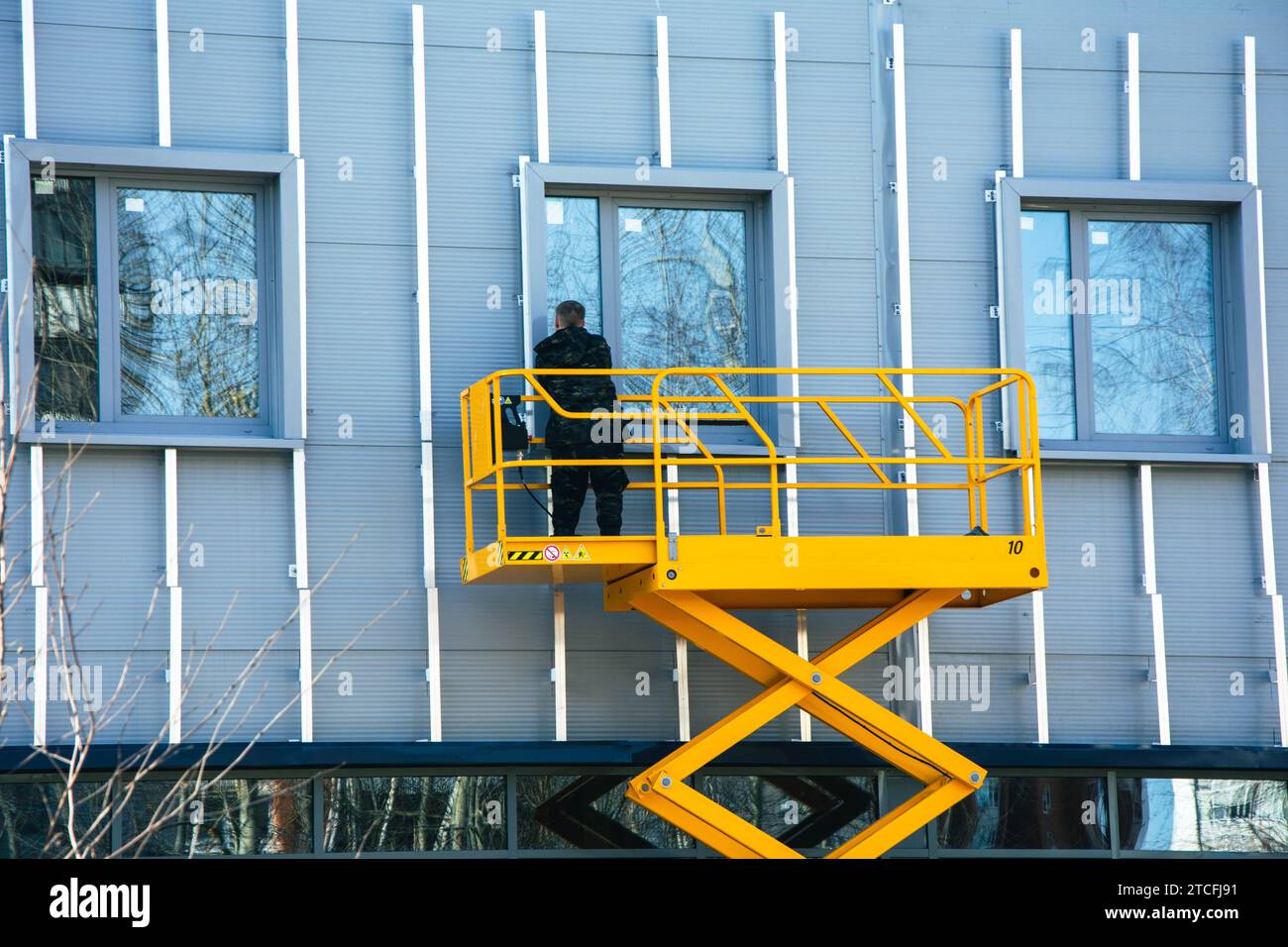 Professional worker is skillfully positioning a crate for the cladding ...