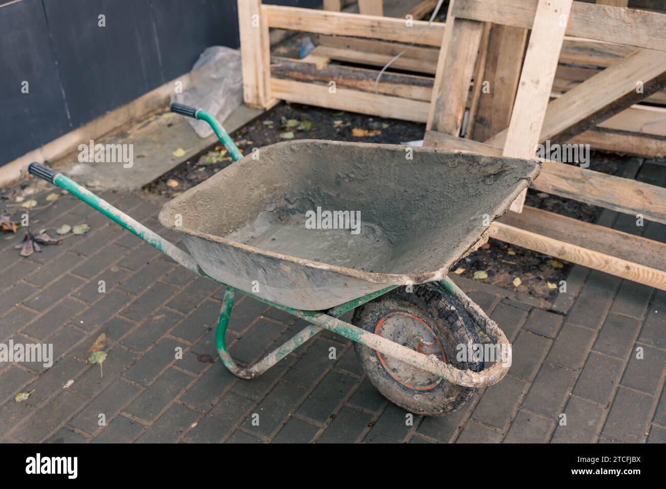 A heavy-duty construction wheelbarrow parked at a busy construction ...