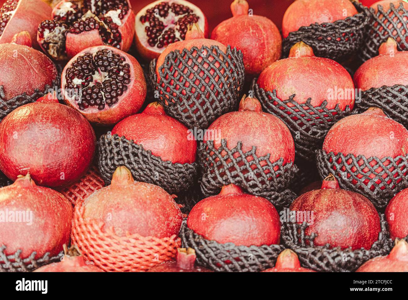 A close-up shot of fresh pomegranates neatly arranged on a wooden shelf ...
