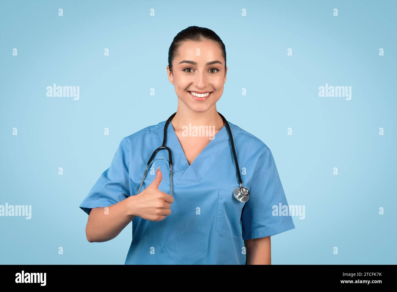 Happy female nurse giving thumbs up and smiling Stock Photo - Alamy