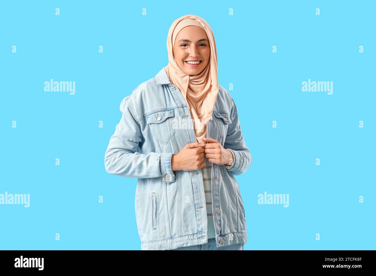 Stylish Muslim woman in denim jacket on blue background Stock Photo - Alamy