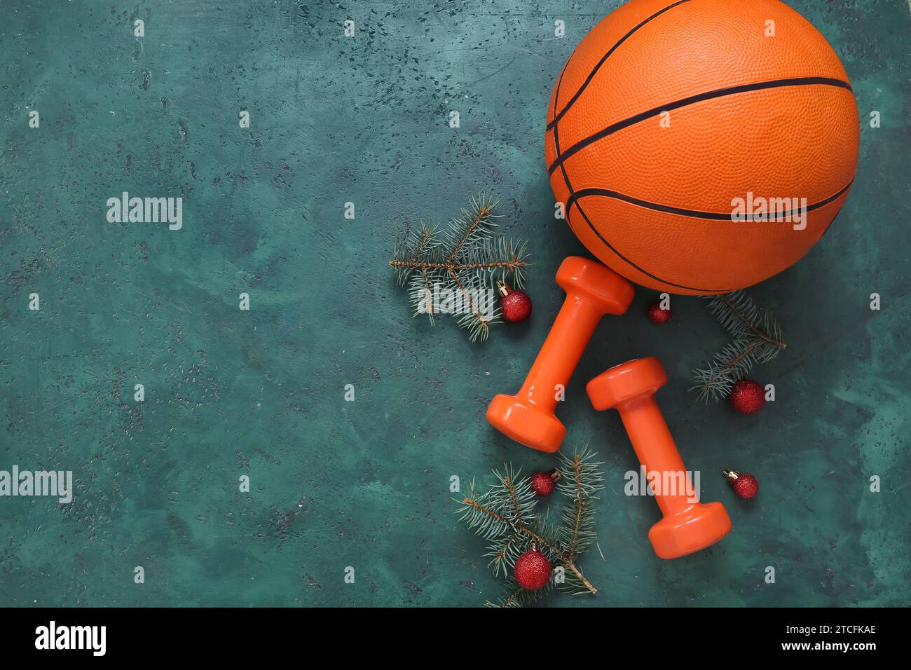 Composition with basketball ball, dumbbells and Christmas tree branches ...