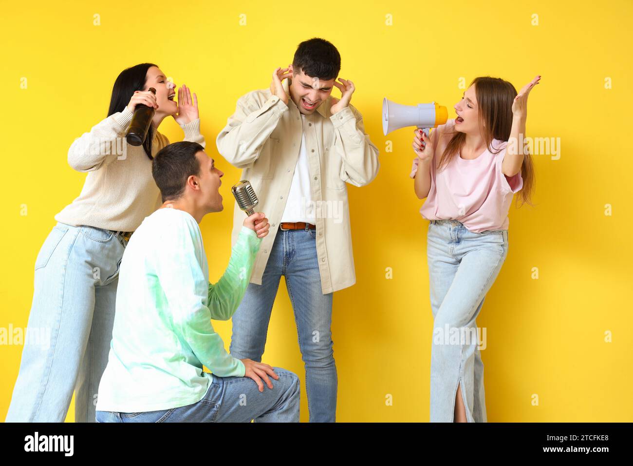 Young man suffering from loud neighbours on yellow background Stock ...