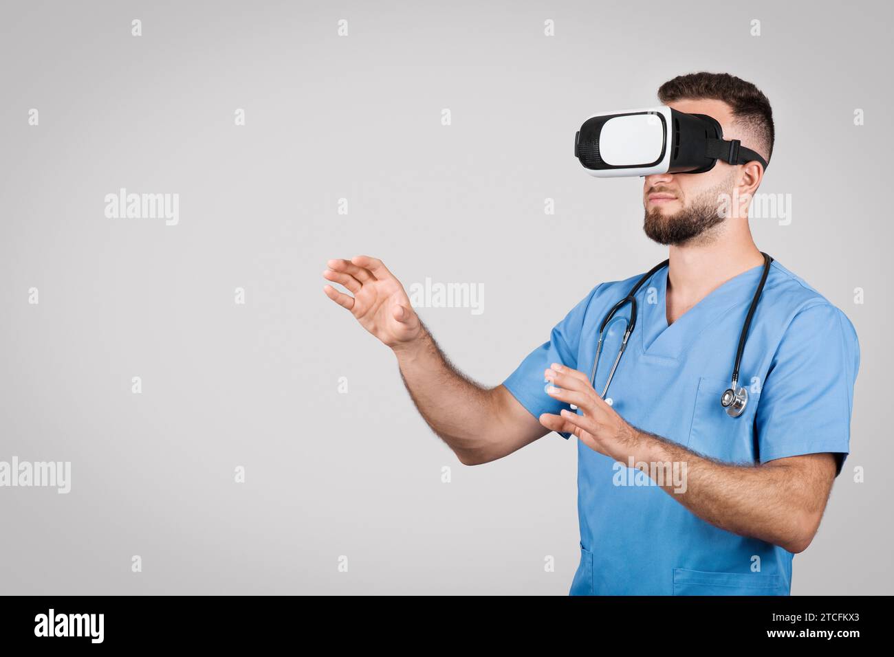 Male nurse in blue scrubs using a VR headset, copy space Stock Photo ...