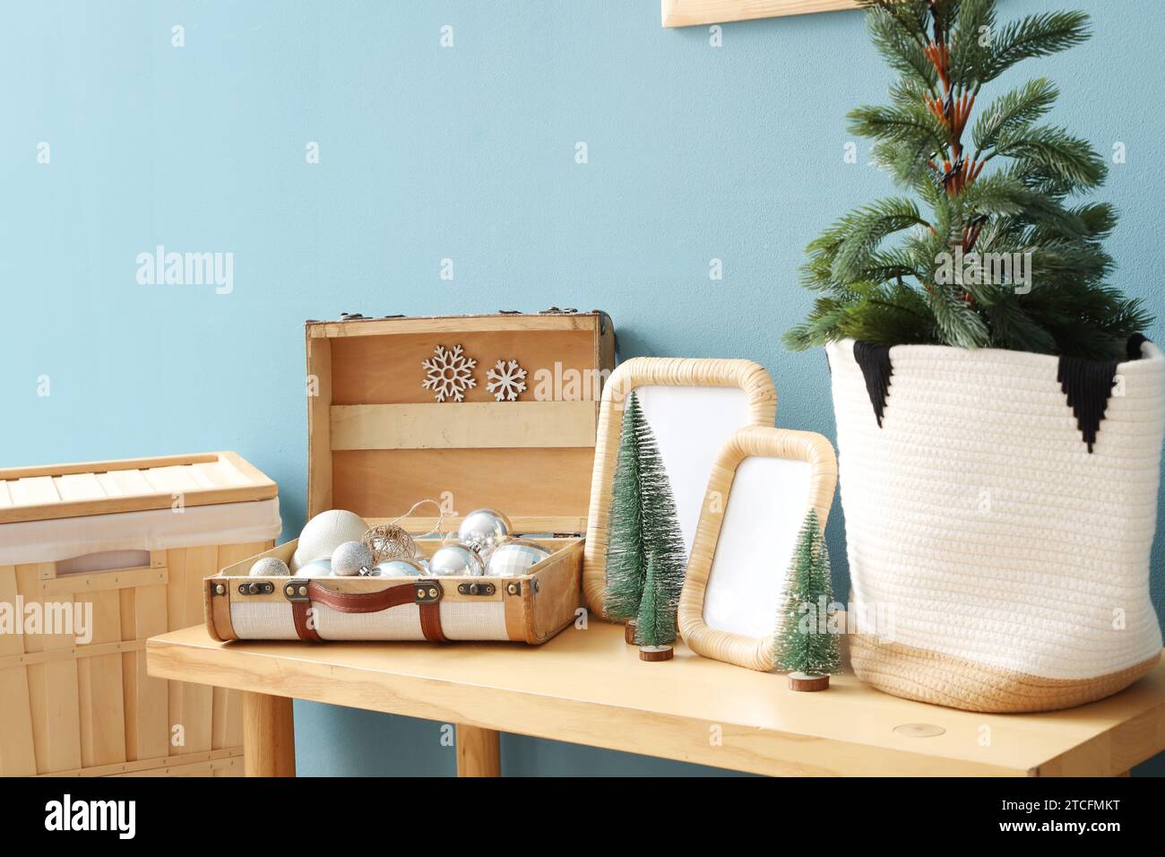 Wooden bench with blank frames, mini Christmas trees and baubles in ...