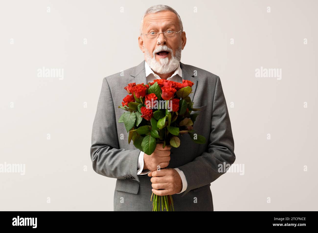 Shocked mature man with bouquet of roses on white background. Valentine ...