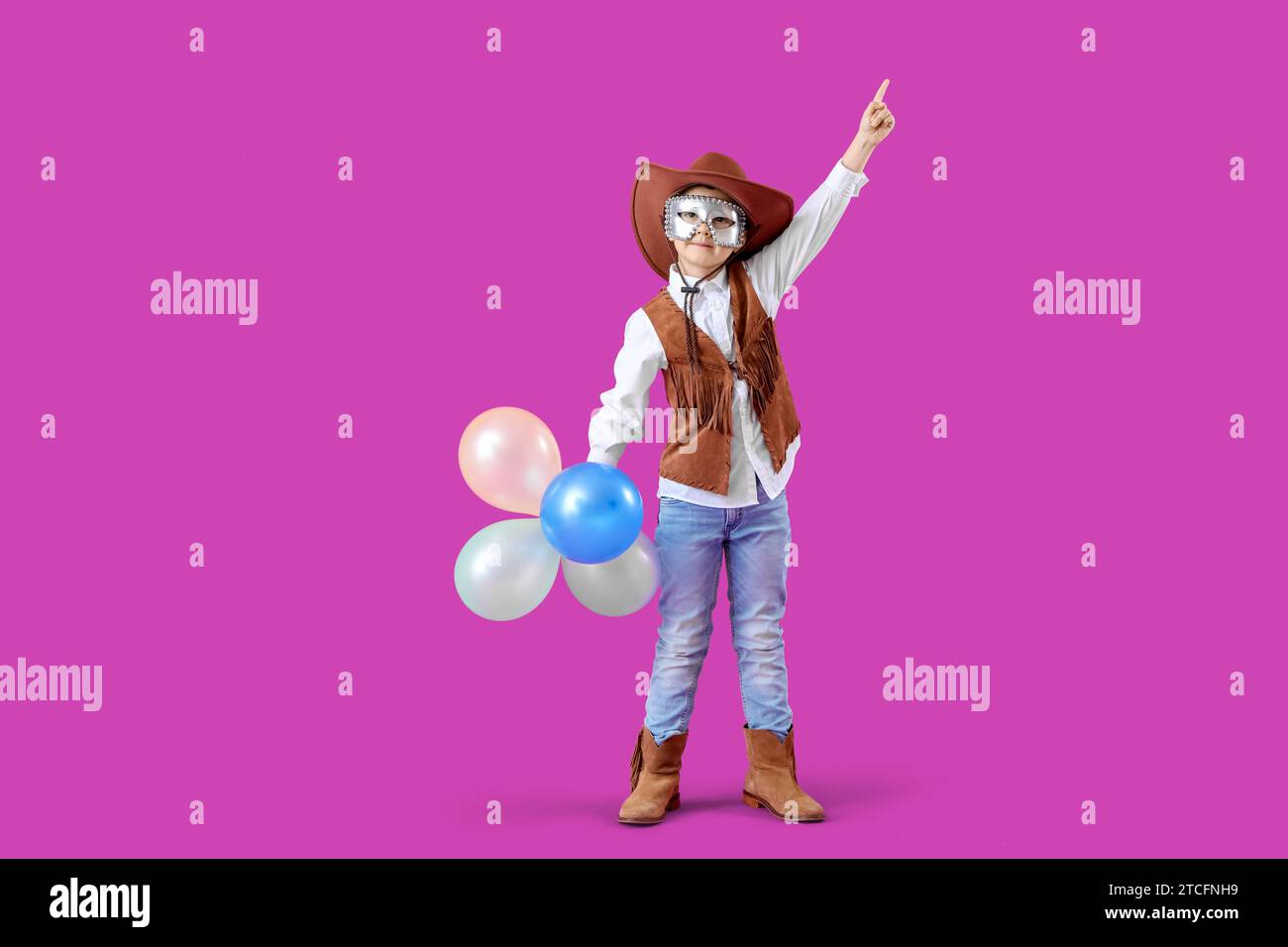 Funny little boy in cowboy costume and carnival mask pointing at ...