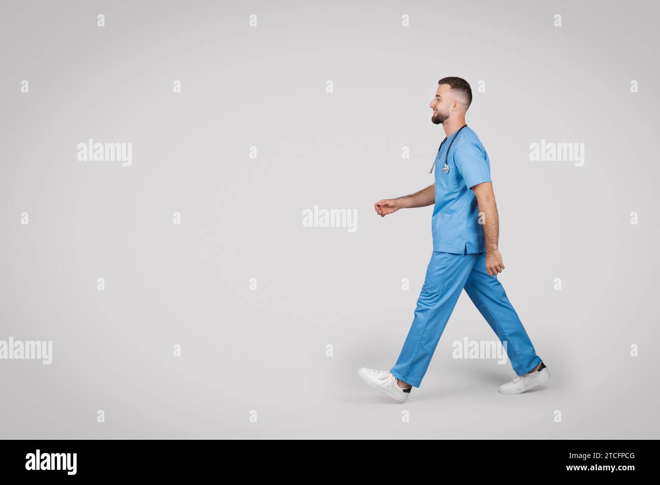 Male nurse walking confidently, wearing blue scrubs Stock Photo - Alamy