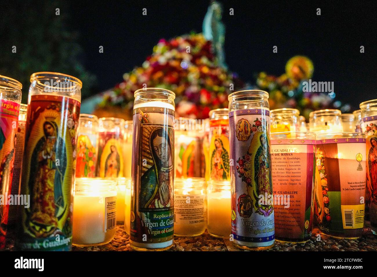 Hundreds of candles are lit at the feet of a Lady of Guadalupe statue ...