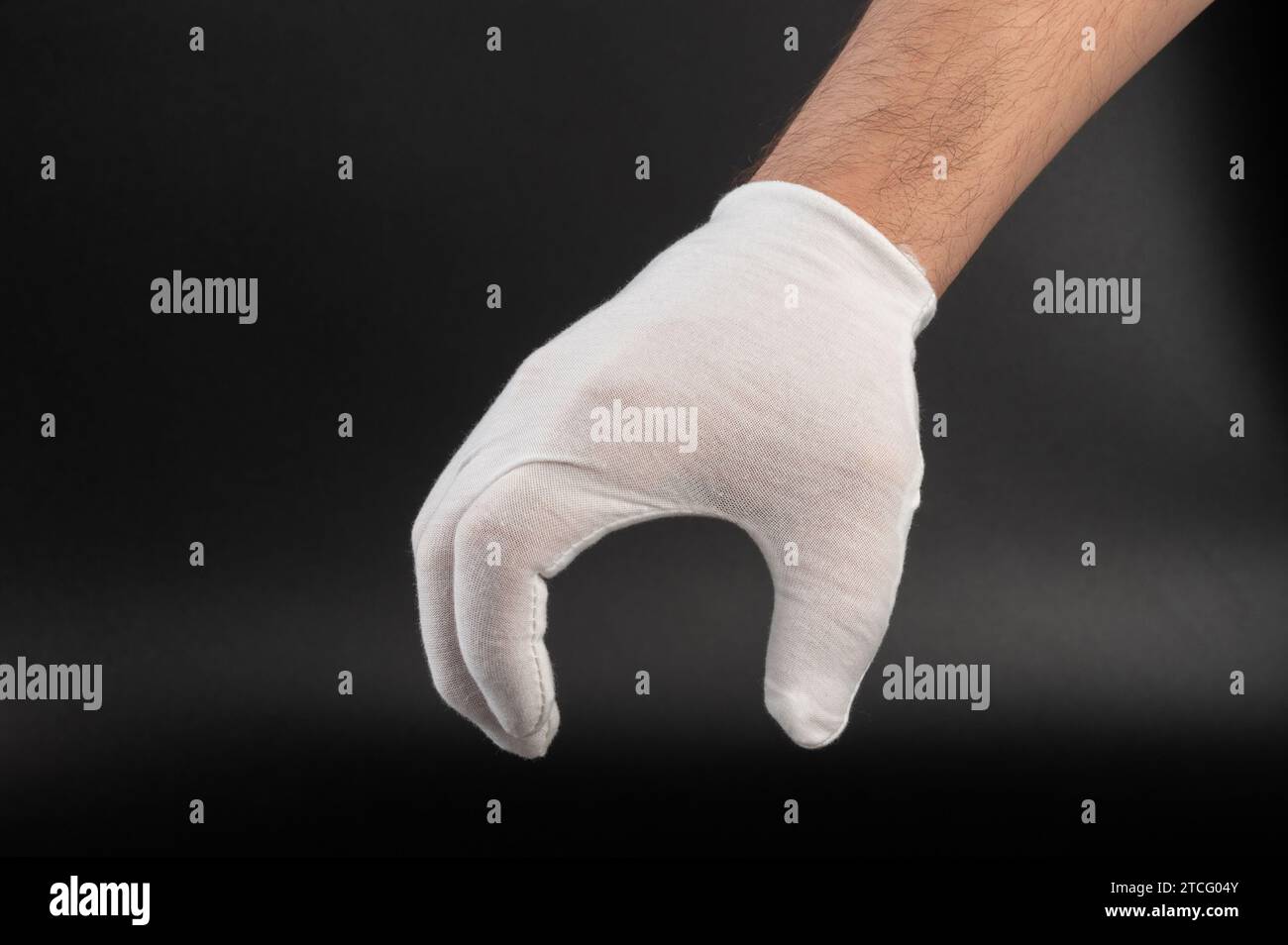 Hand in white gloves in holding gesture isolated on black studio ...