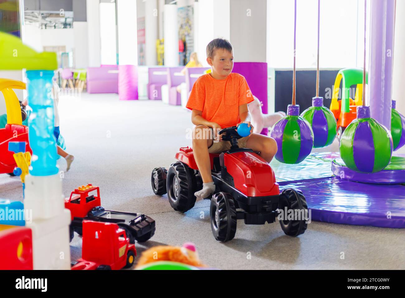 A child rides a toy pedal car at a children's play center Stock Photo ...