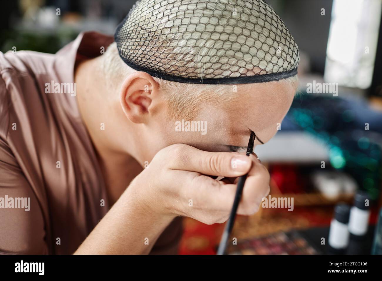 Close up of drag queen performer drawing on eyebrows and doing makeup ...