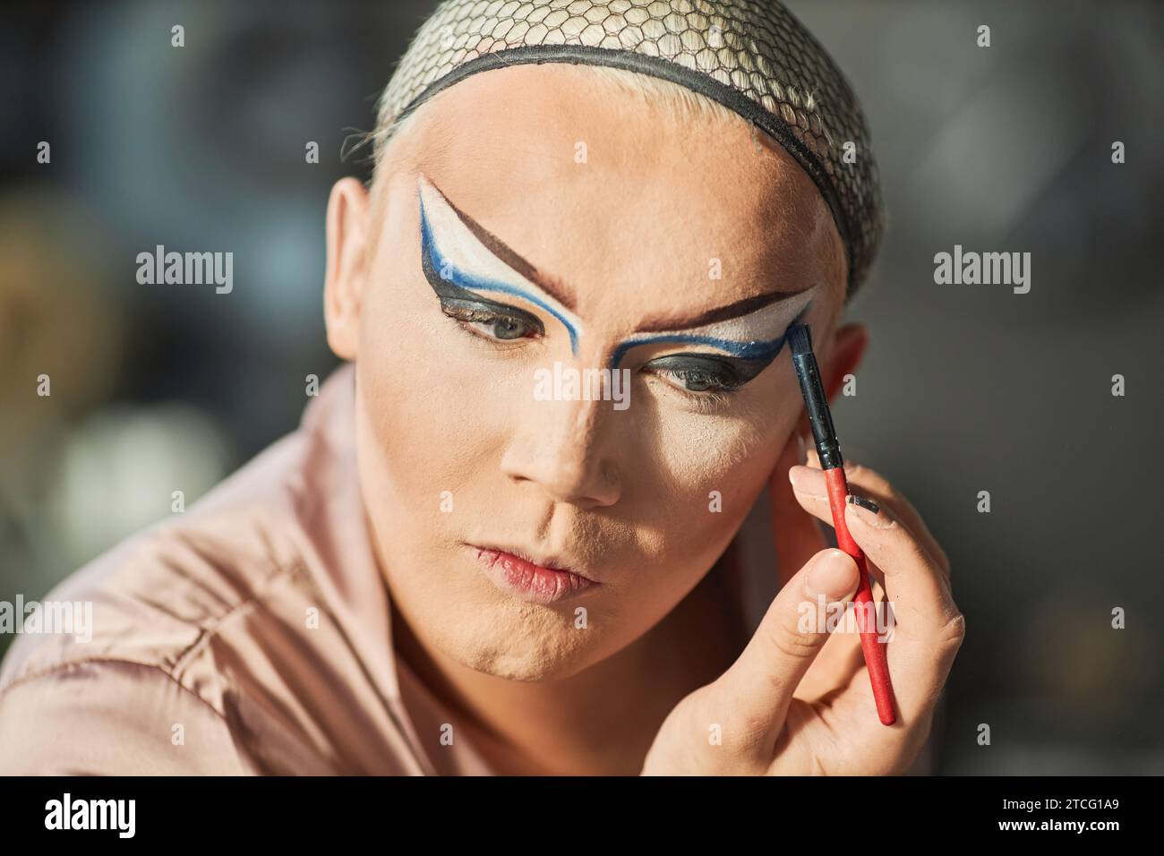 Portrait of drag queen performer doing stage makeup with graphic ...