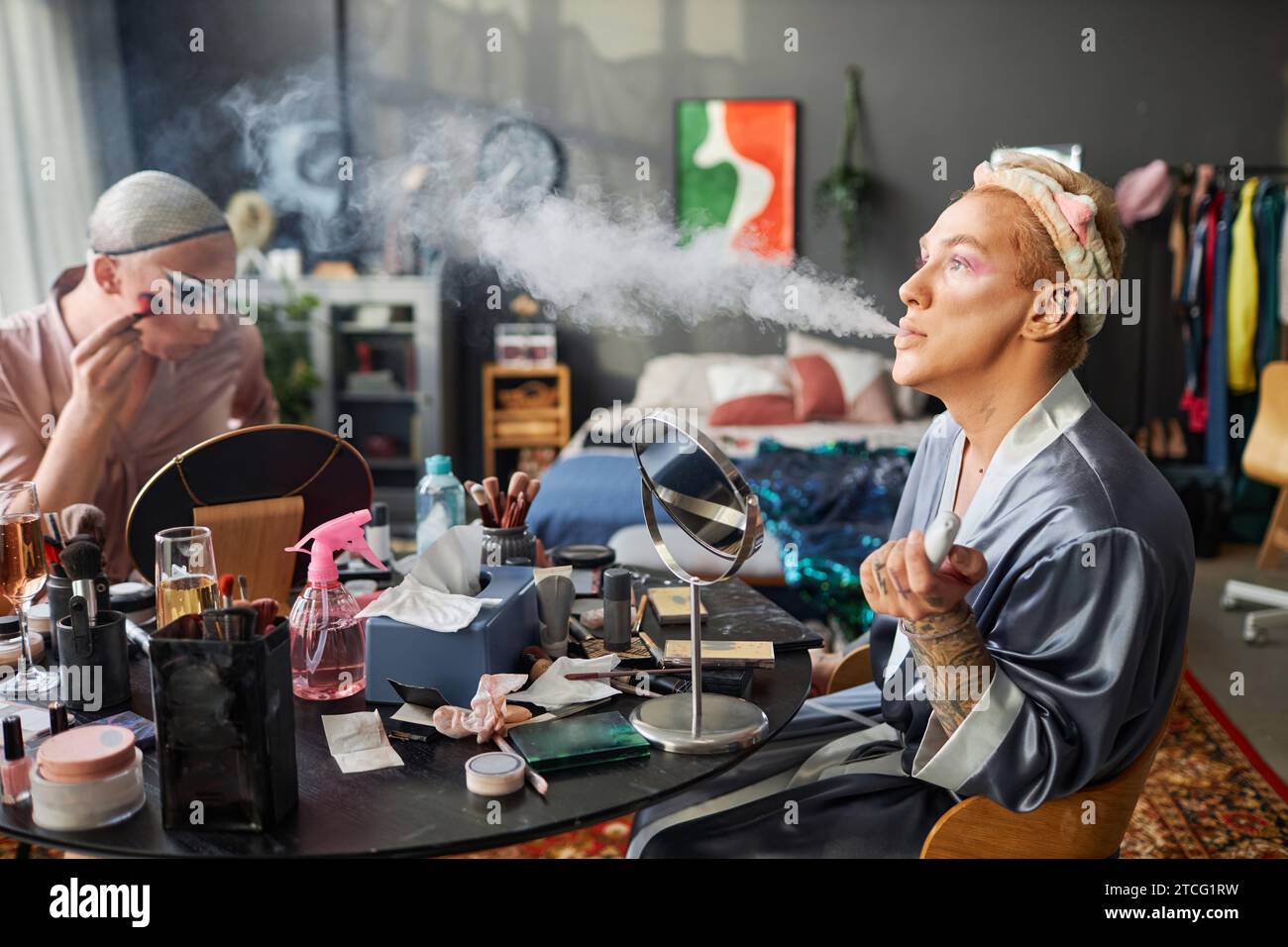 Side view portrait of male drag queen performer blowing smoke clouds ...