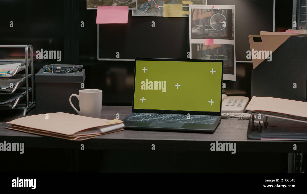 Modern laptop with greenscreen placed on archive desk in police ...