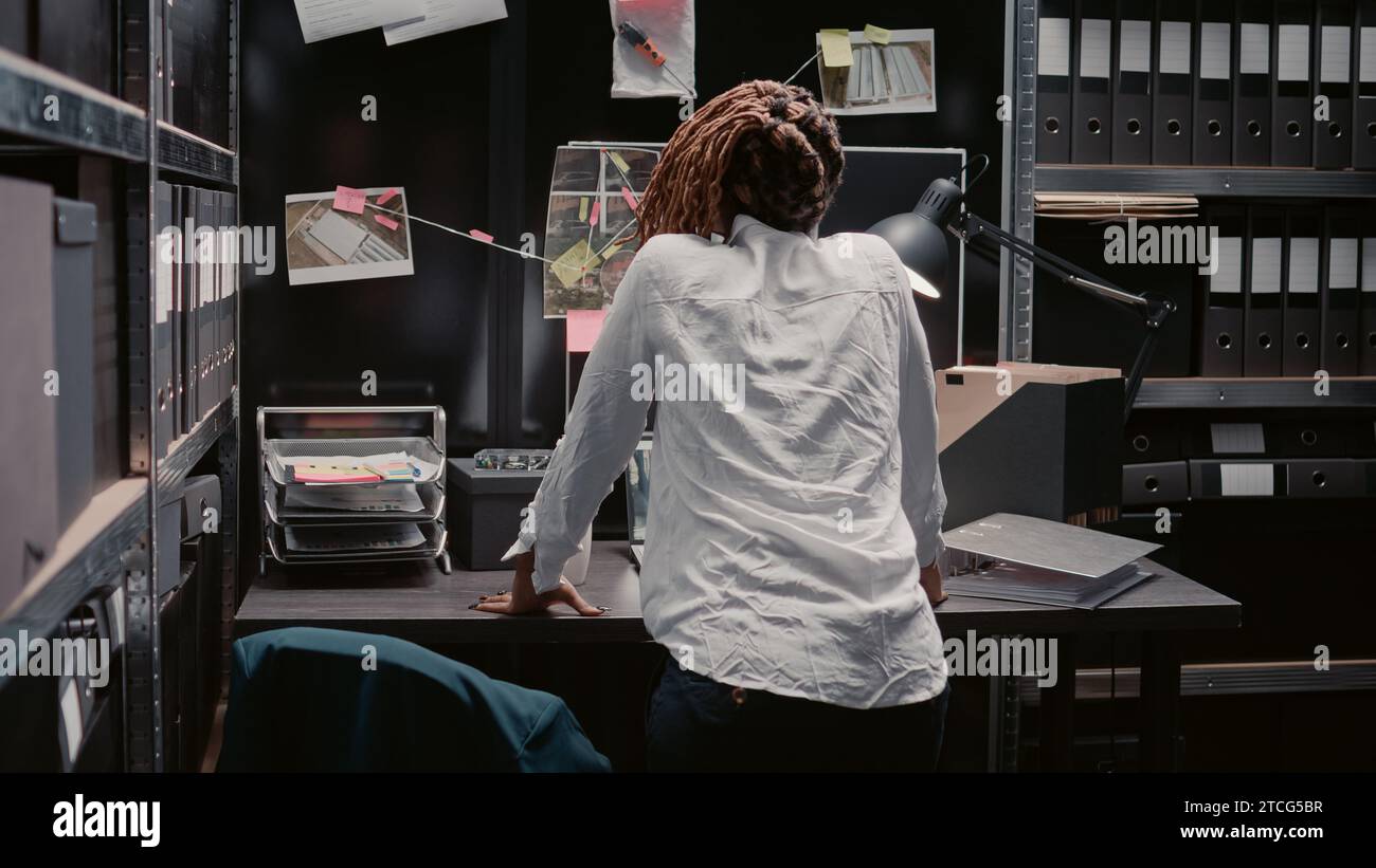 Detective inspector examining case information on map, conducting ...