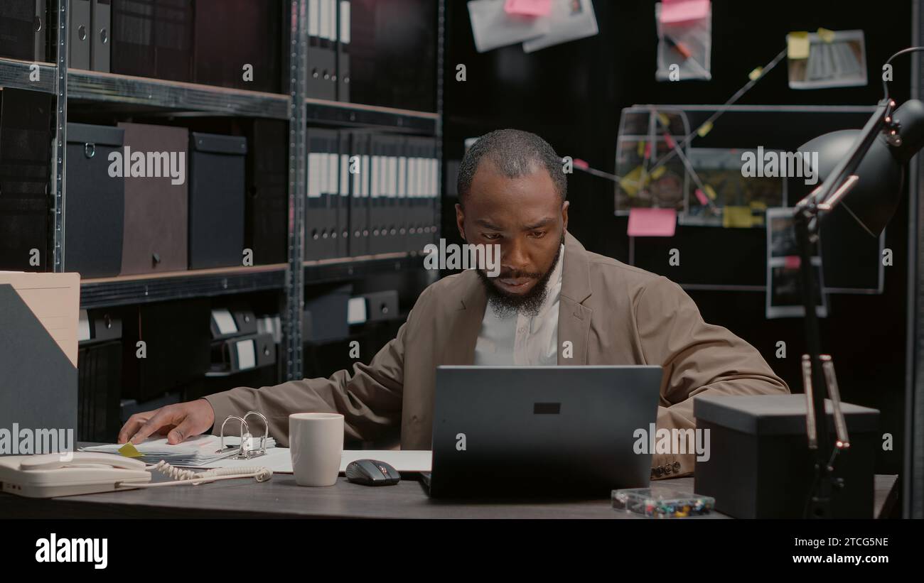 Police officer putting crime case photo on wall board, analyzing clues ...