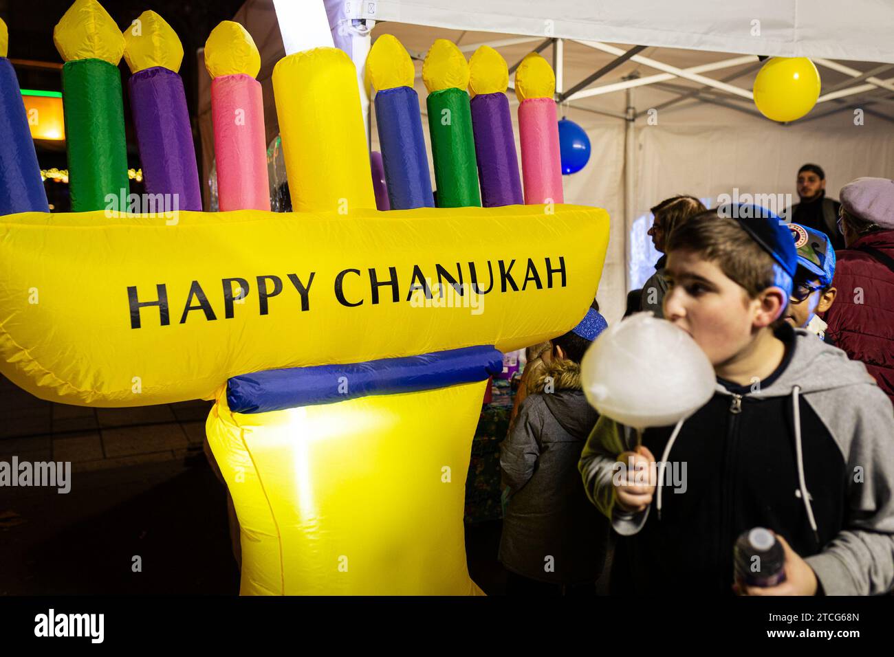 A Jewish kid eats cotton candy during the Hanukkah festivities. The ...