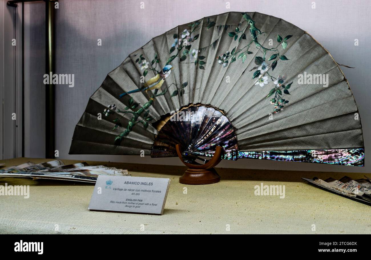 Ornate hand fan with mother-of-pearl and gold details on stand ...