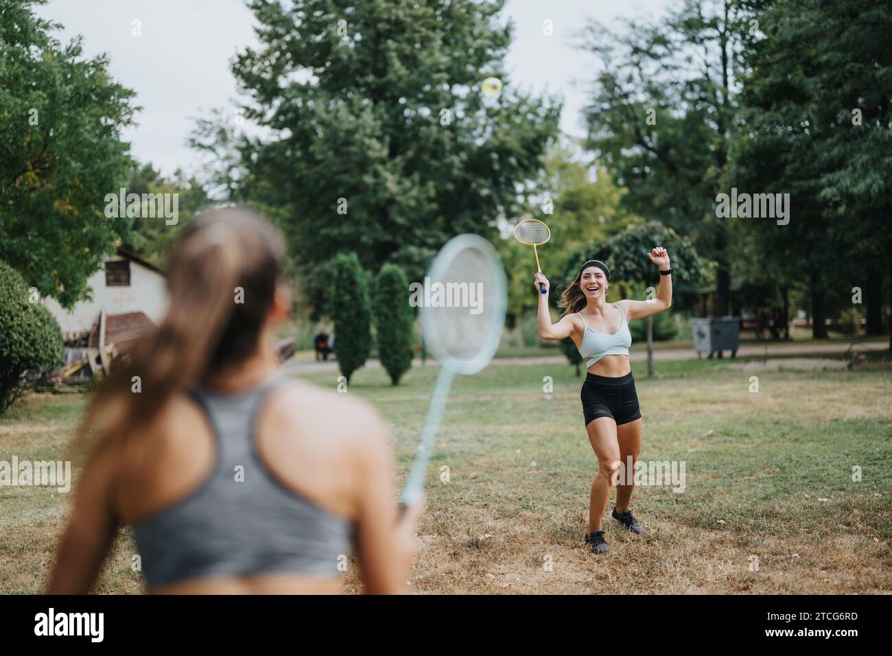 Fit athletes playing badminton in a park. Friends having fun and ...