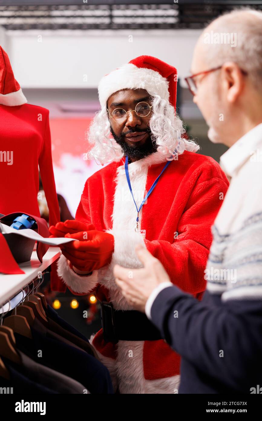 Worker presenting ties to senior man, recommending accessories for ...