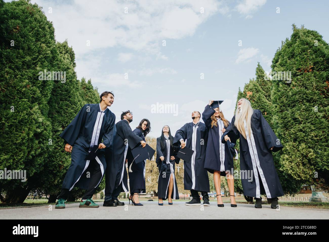 Group of students congratulating each other, they throw their caps in ...