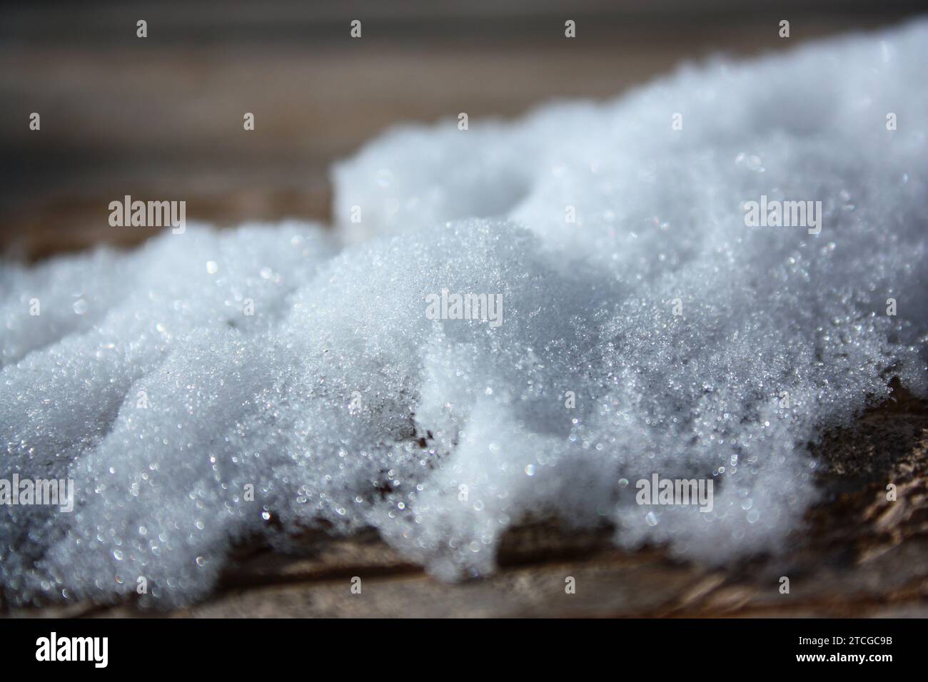a snowball on a wooden base glitters in the sun. High quality photo ...