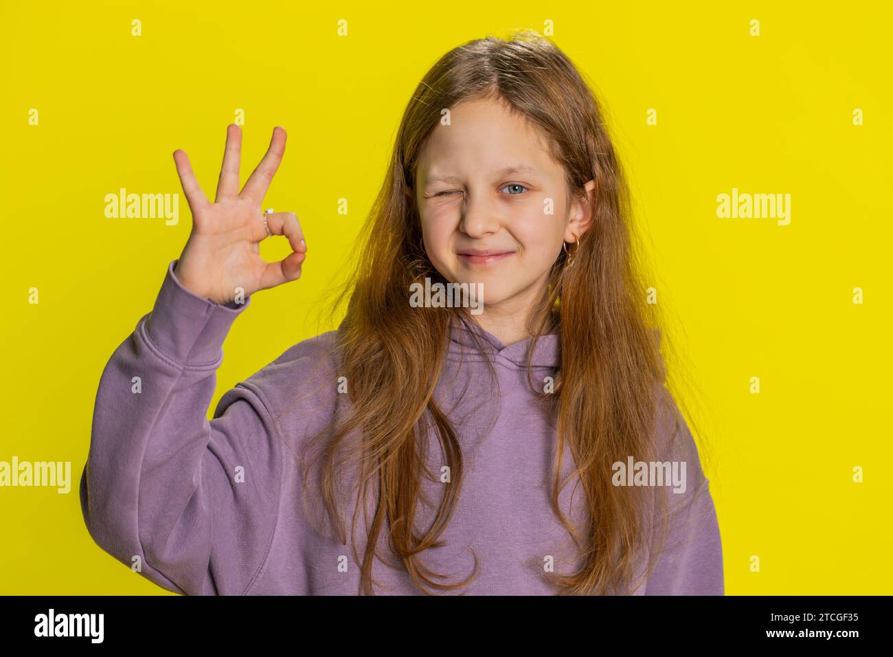 Okay. Happy young preteen child girl kid looking approvingly at camera ...